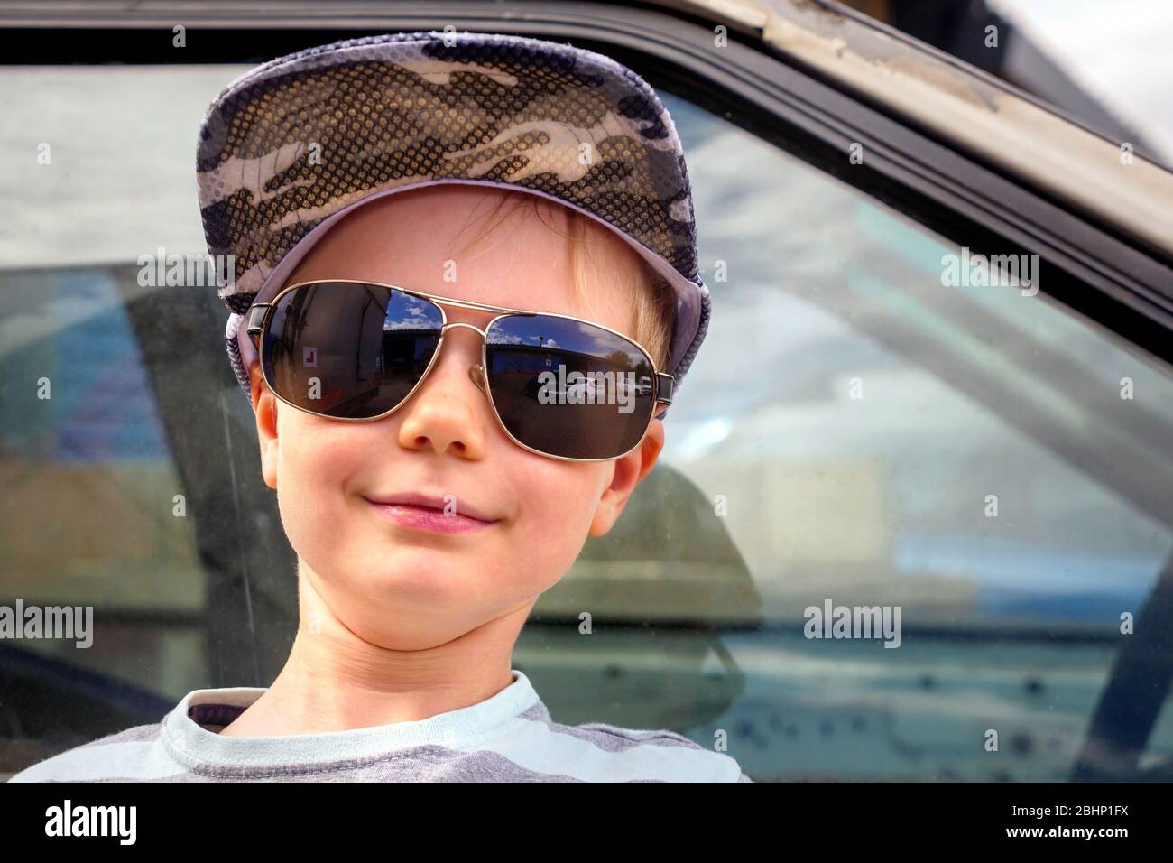 little boy portrait with car window on backgroung wearing military cap ...