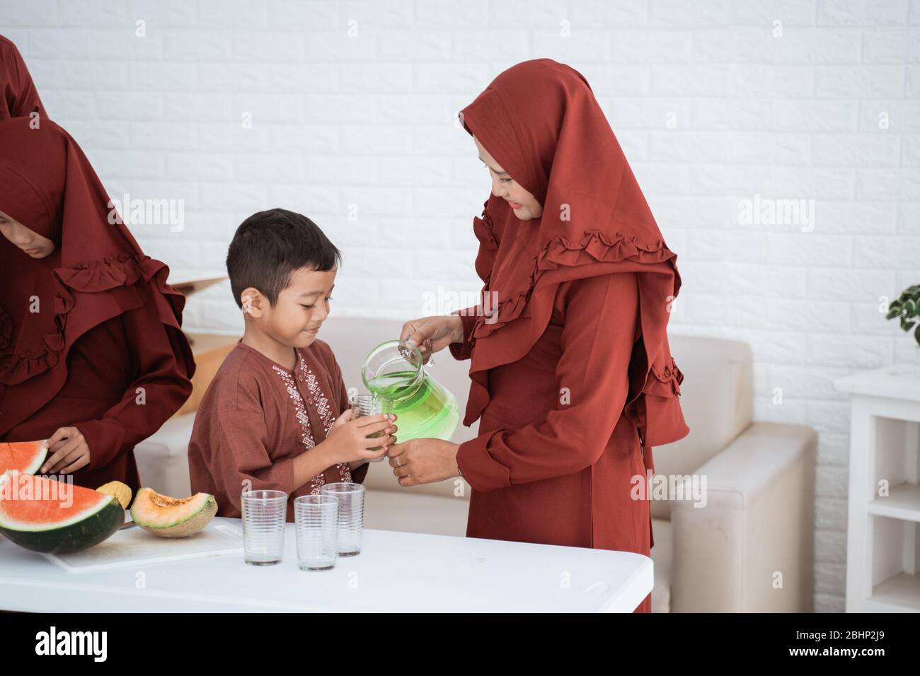 Asian mother pour syrup for child to break fast with family at home ...