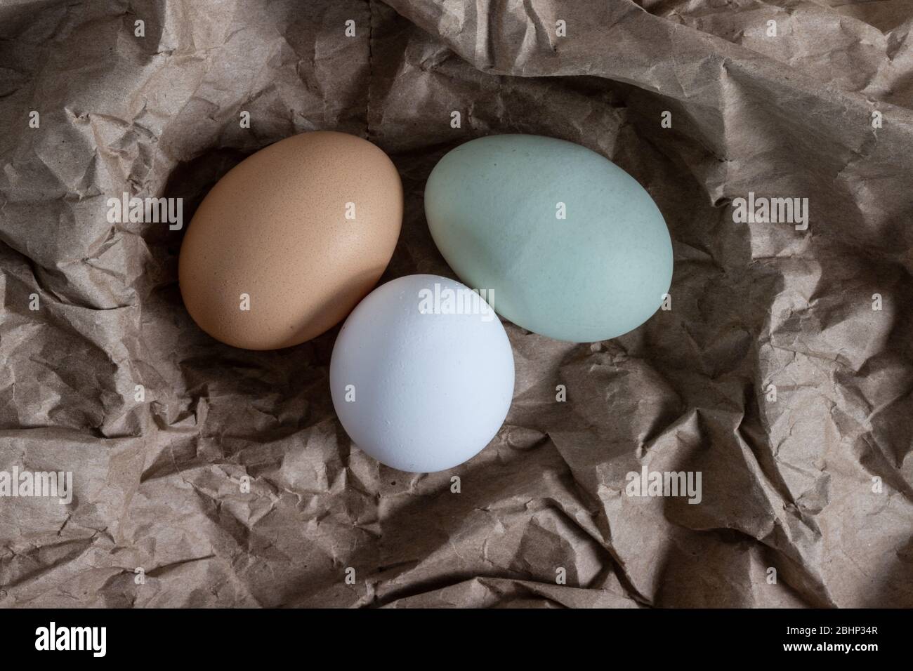 three fresh eggs in different color Stock Photo - Alamy