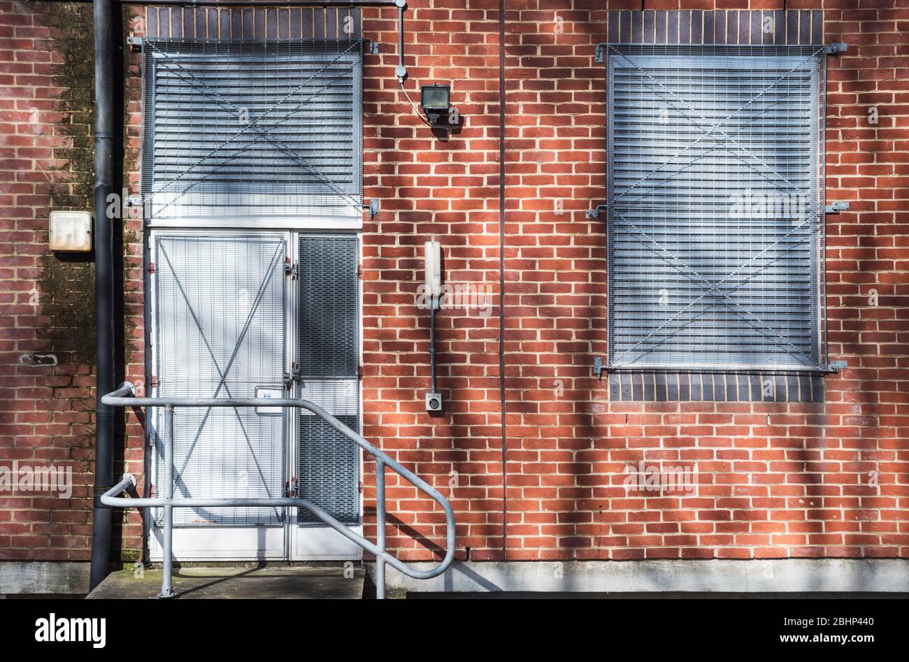 Galvanised steel mesh and bars protect a building's windows and door ...