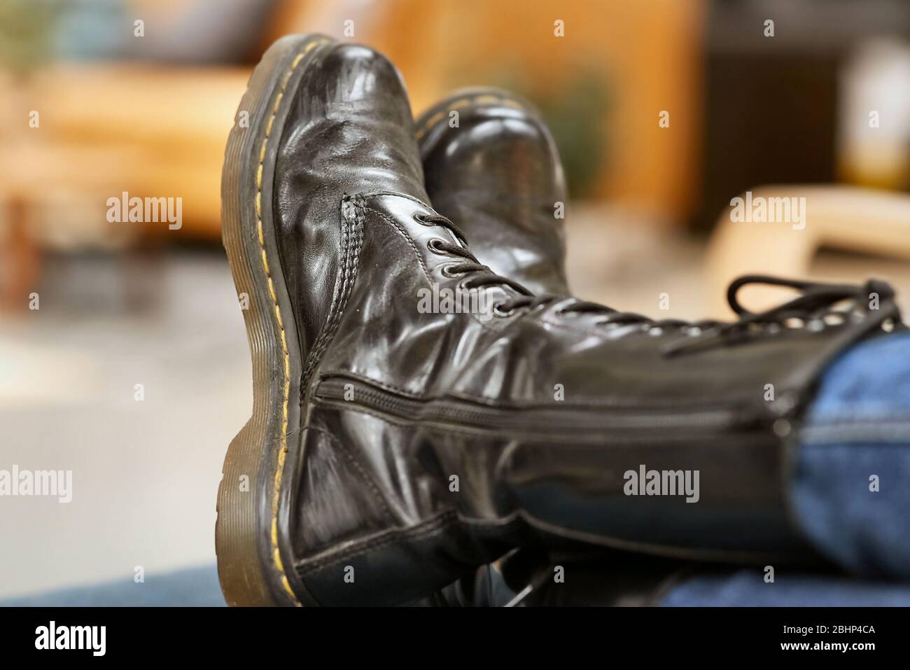 Leather boots legs up on a chair Stock Photo - Alamy