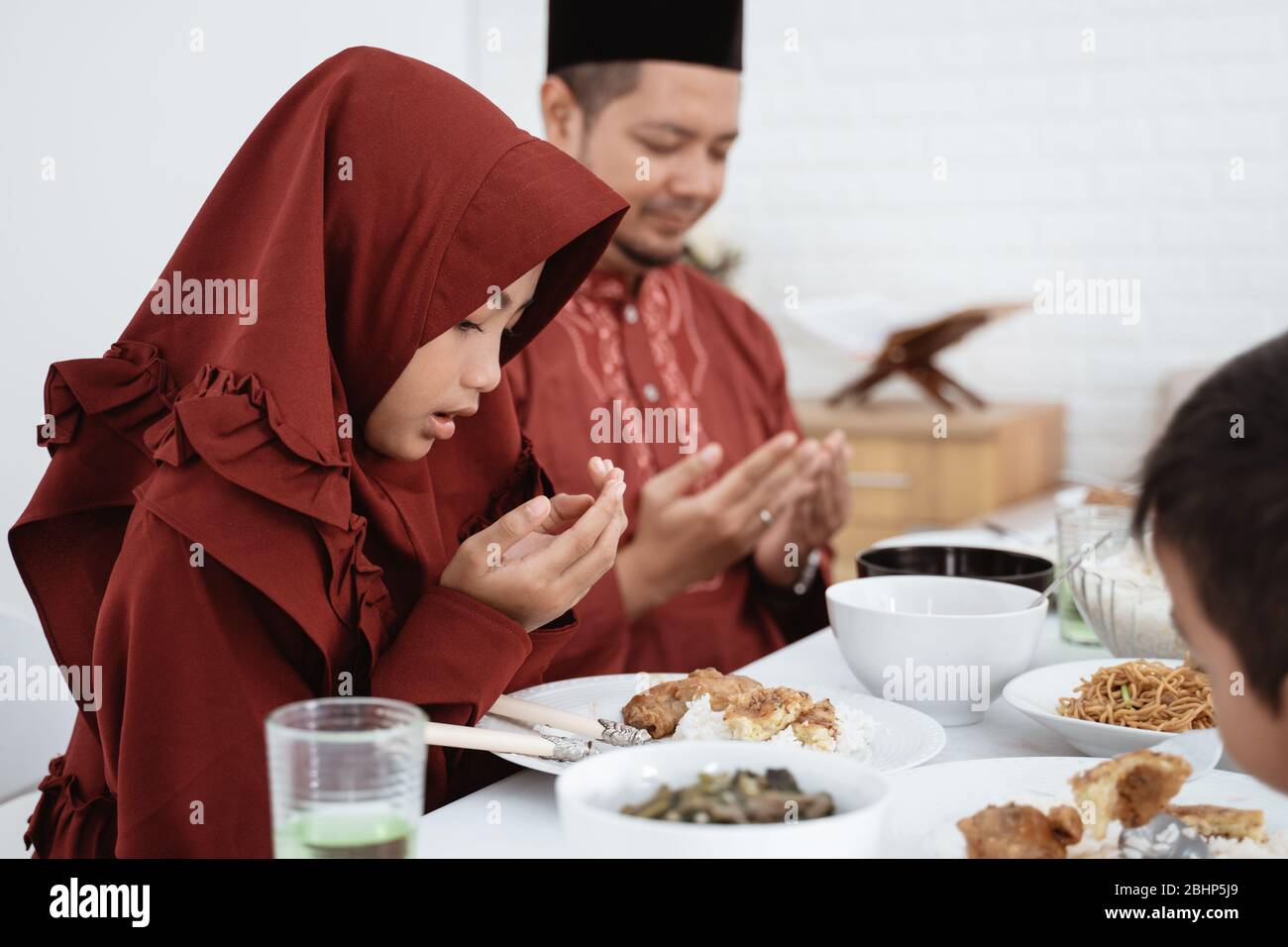 Asian family sit and pray when breaking fast together at home Stock ...
