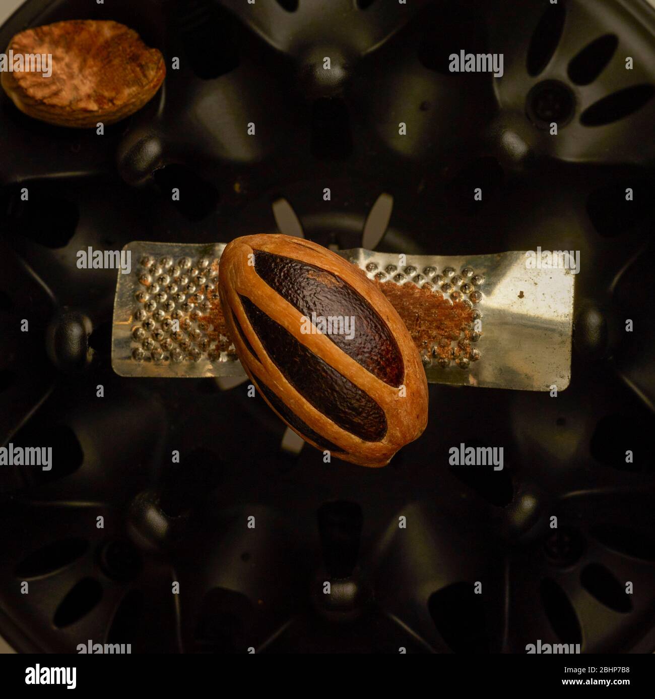 Nutmeg and small grater food still-life close-up against plain ...