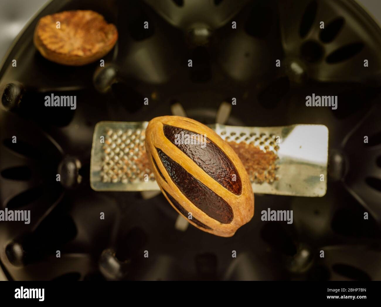 Nutmeg and small grater food still-life close-up against plain ...