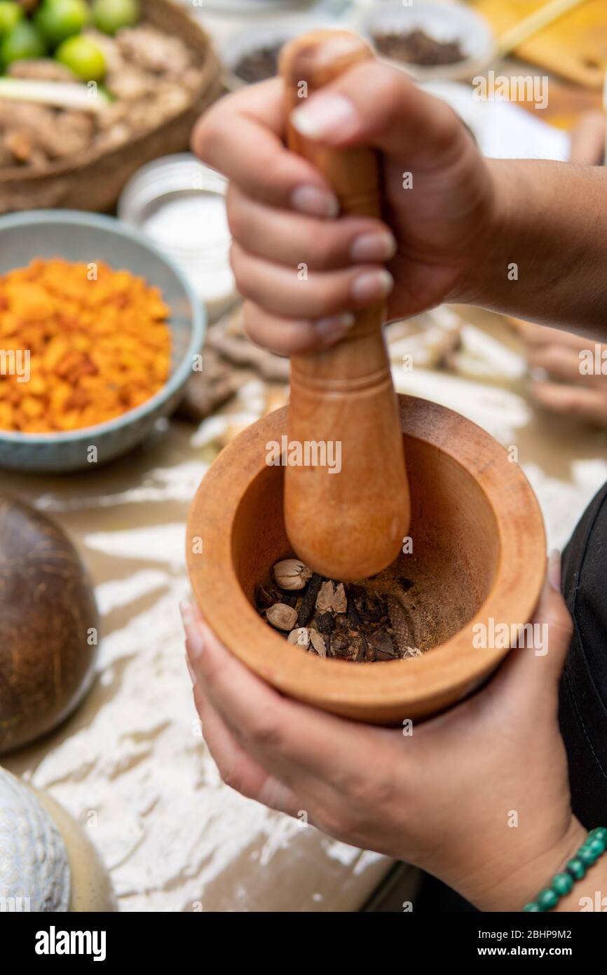 grinding cardamom, clove and traditional spice ingredient for jamu ...