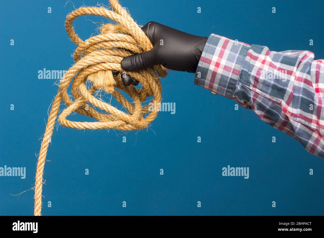 Yellow rope in the expert hand of an adult with protection. Thick rope ...