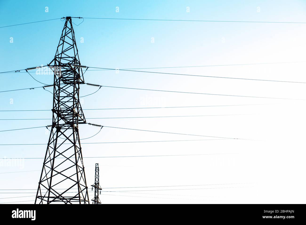Electrical supports with wires against a clear blue sky. Electrical ...