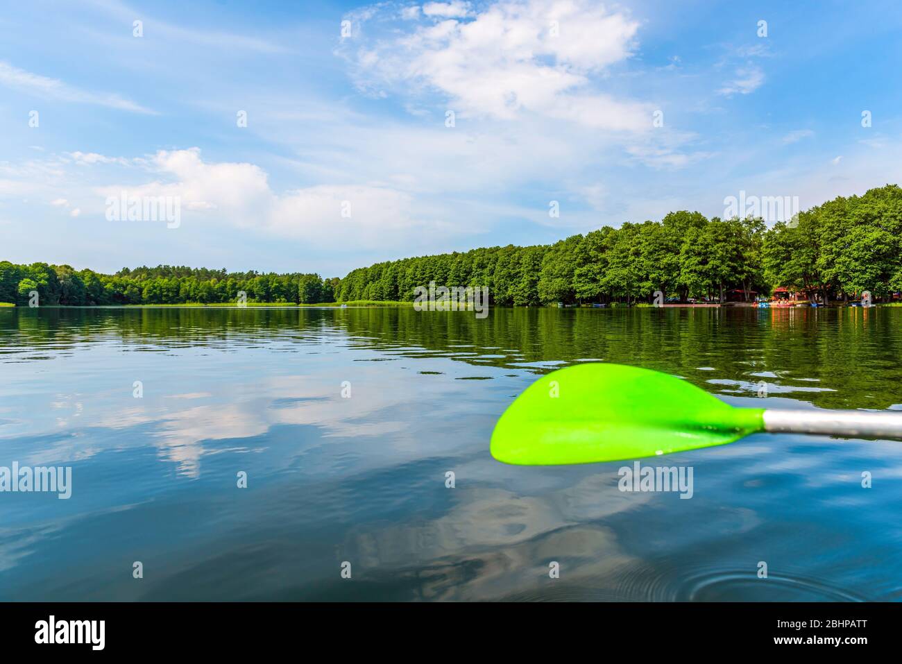 Beautiful nature scene on lake with green kayak paddle. Kayaking on a ...