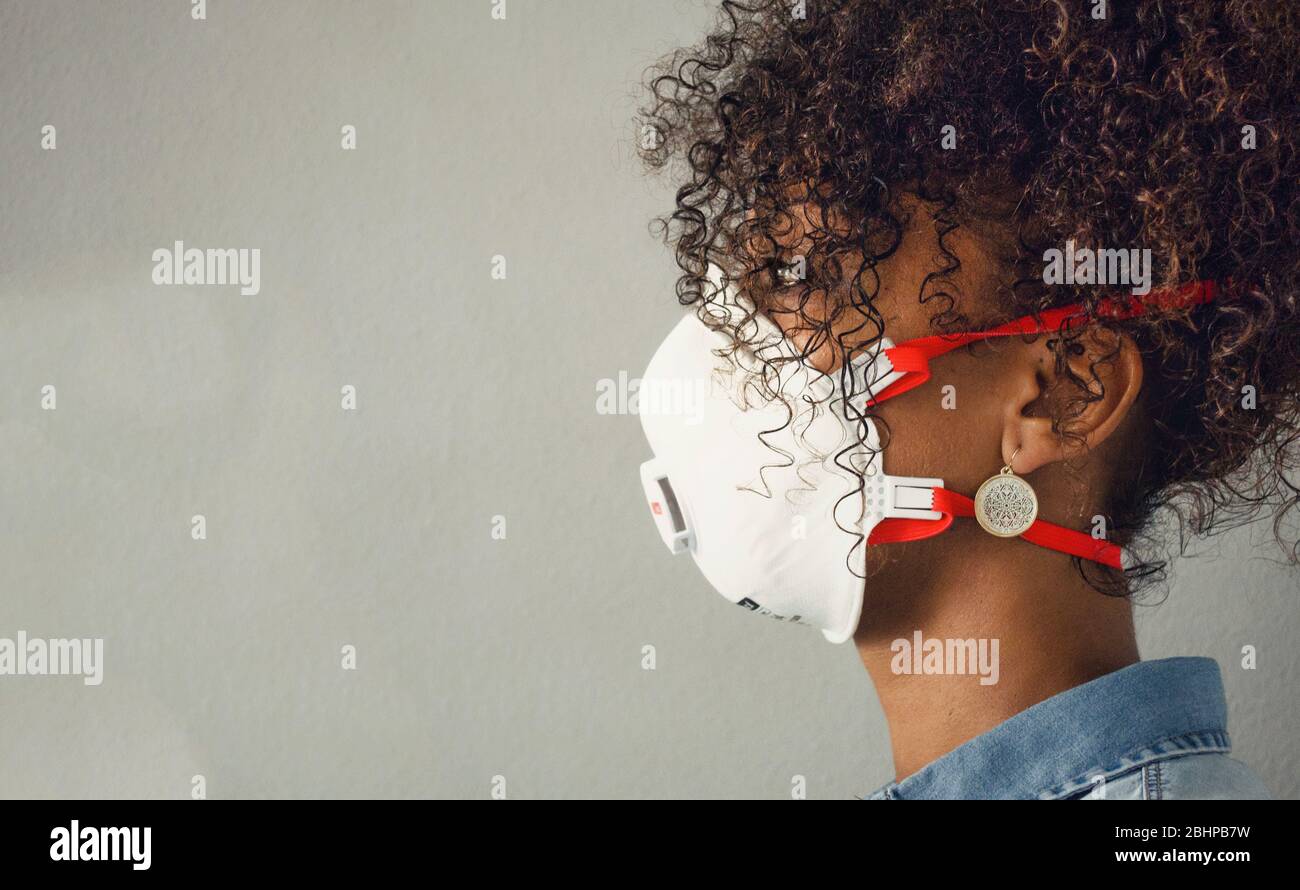 Profile of a black woman wearing a FFP3 mask with an exhalation valve ...