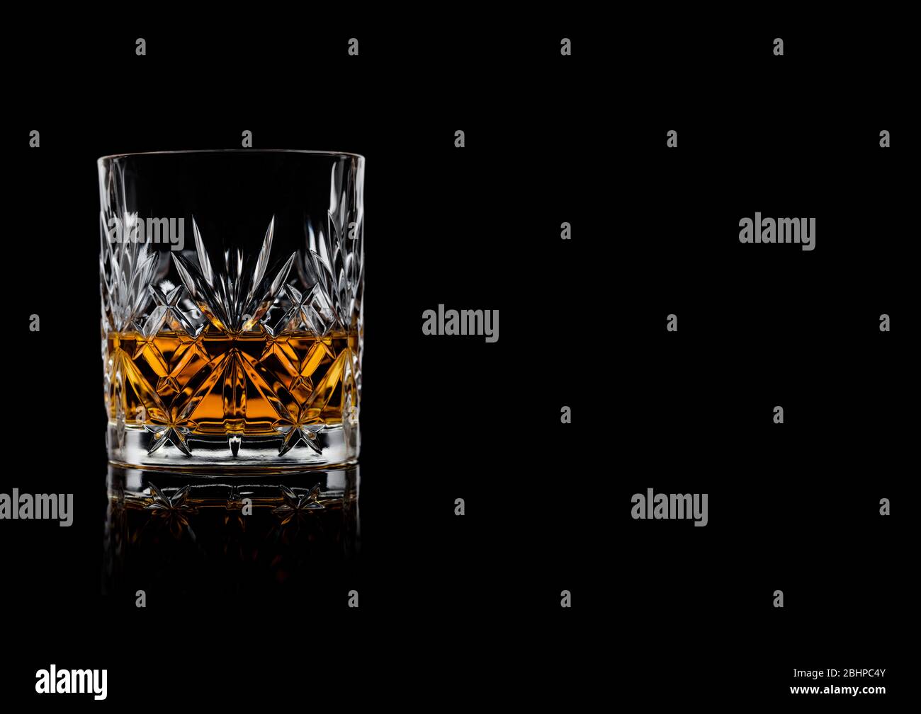 Scotch whiskey in crystal elegant glass on black background with ...