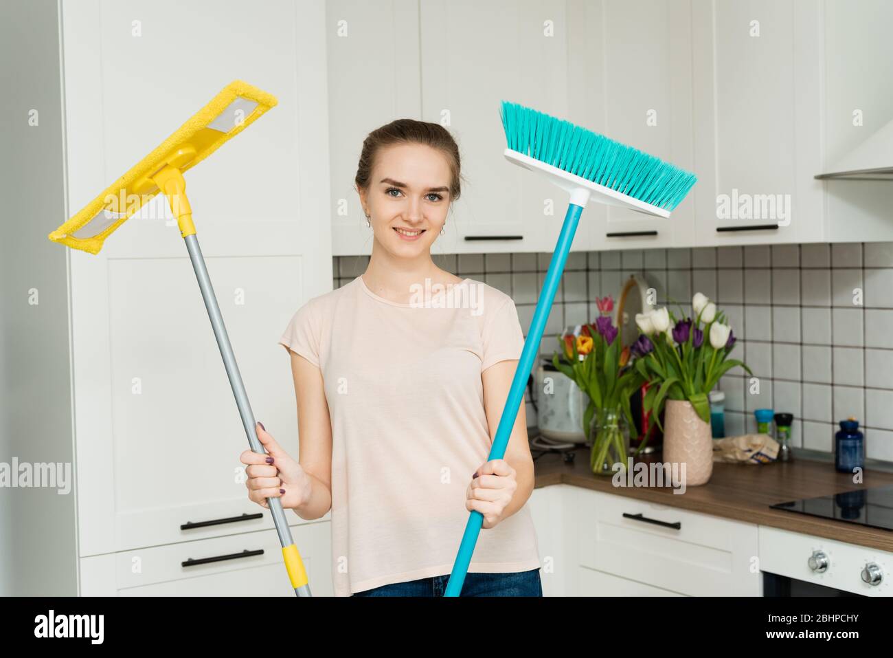 A girl is holding the mops. Woman is ready to clean house. A housewife ...