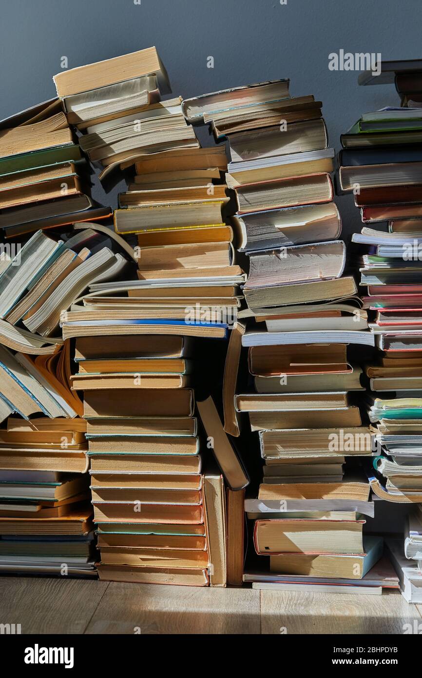 Wall of books piled up Stock Photo - Alamy