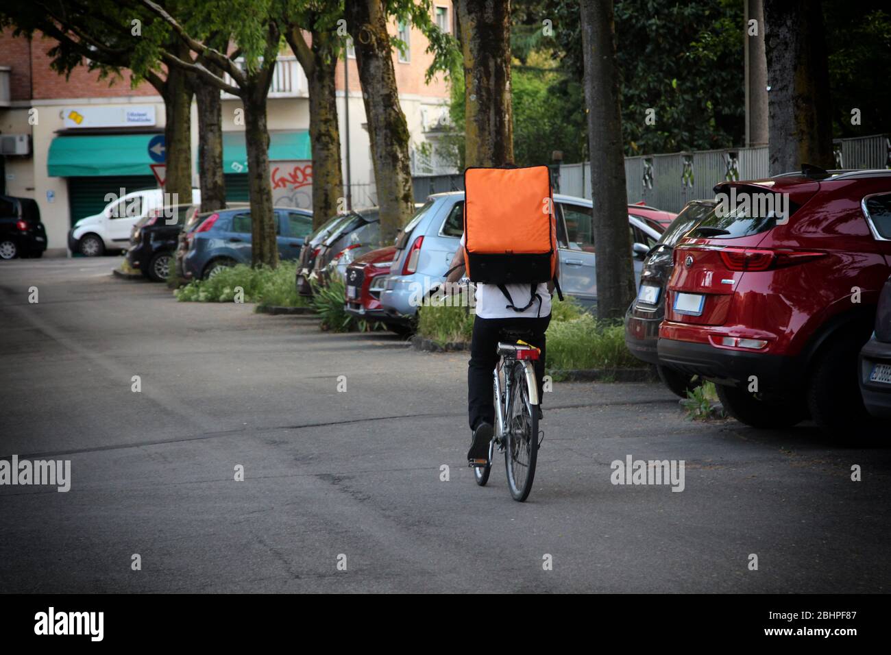 Food delivery rider by bicycle in italian city Stock Photo - Alamy