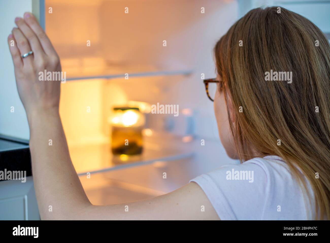 Woman peers into a refrigerator and only sees a jar of pickles in the ...