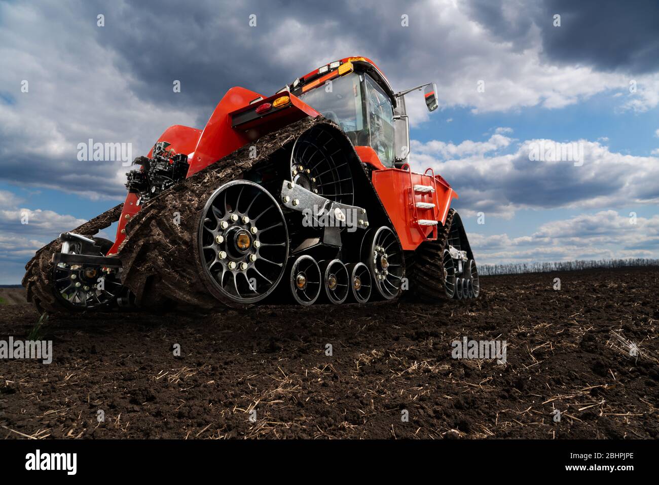 Rubber tracked agricultural tractor on a field Stock Photo - Alamy