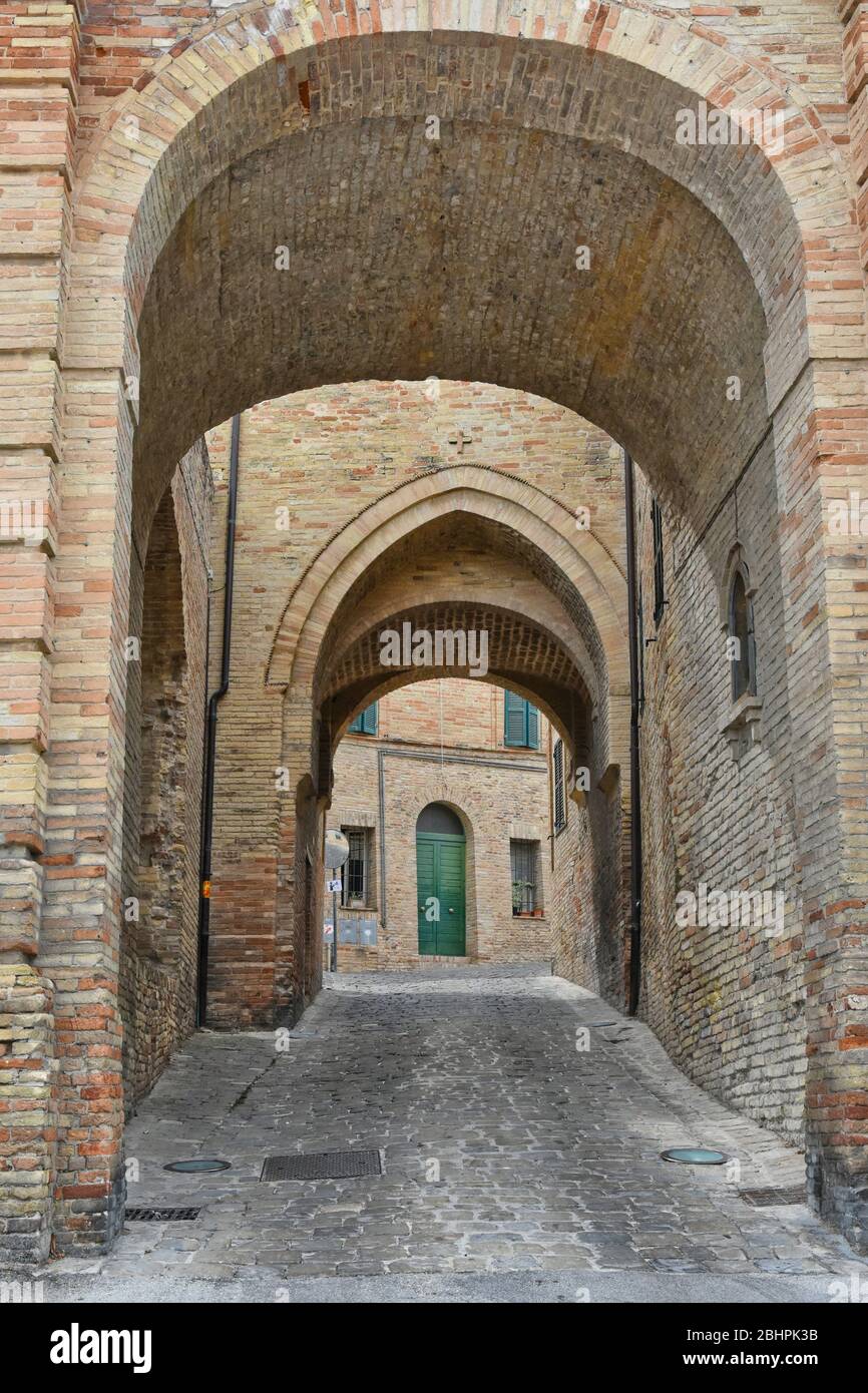A narrow street between the houses of the medieval village of Montelupone in Italy Stock Photo ...