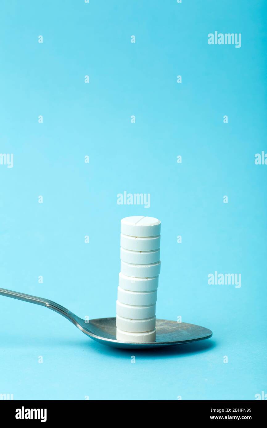 Pills and drugs on a spoon. Dosage and medication. Vitamins, anti ...