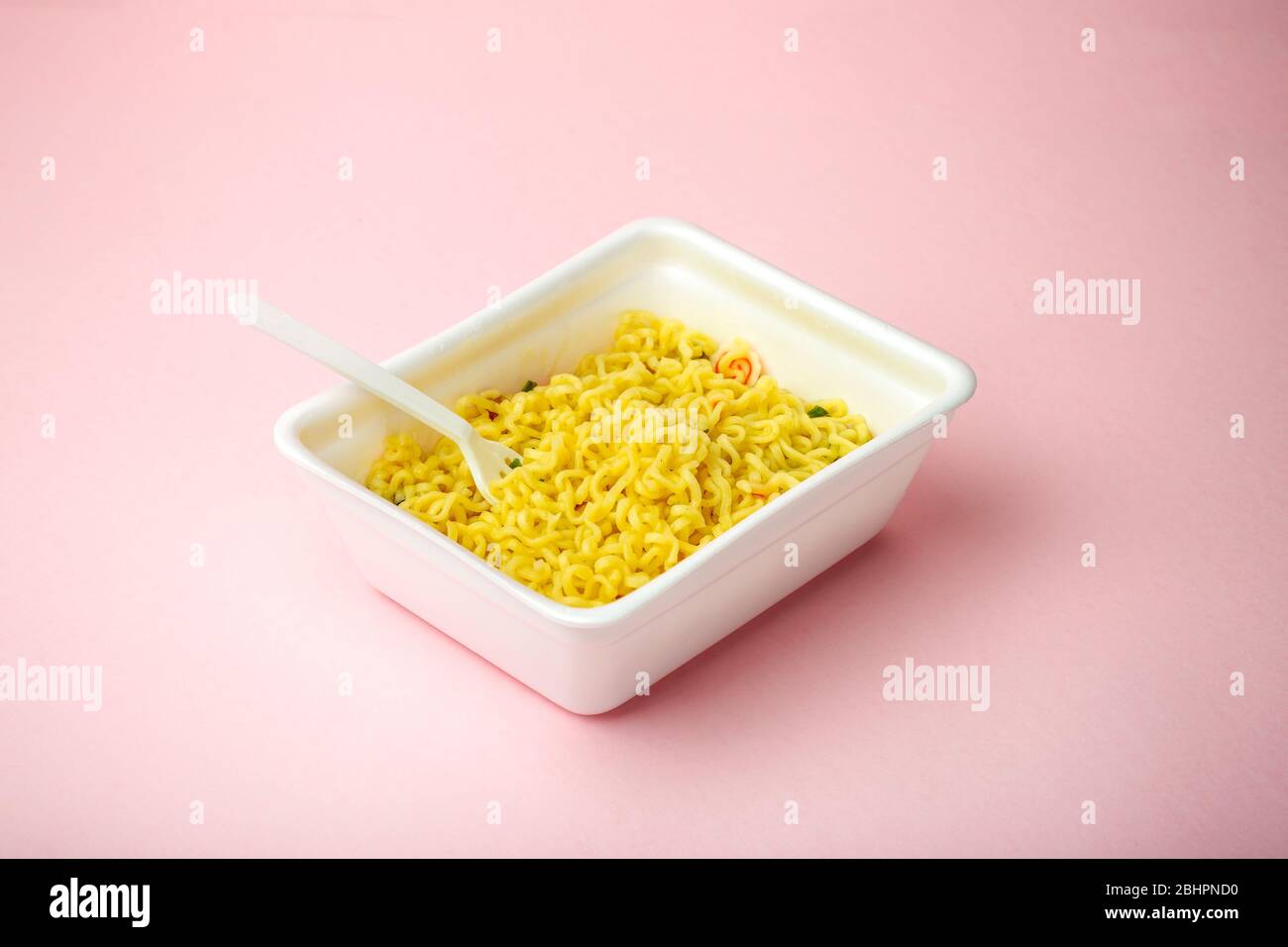 Instant noodles on a pink minimal background in a plastic box. Fast ...