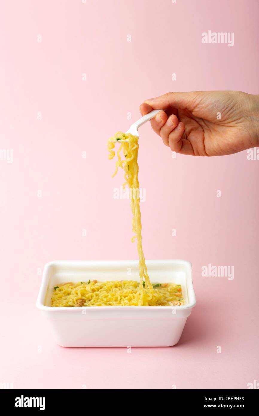 Instant noodles on a pink minimal background in a plastic box. Fast ...