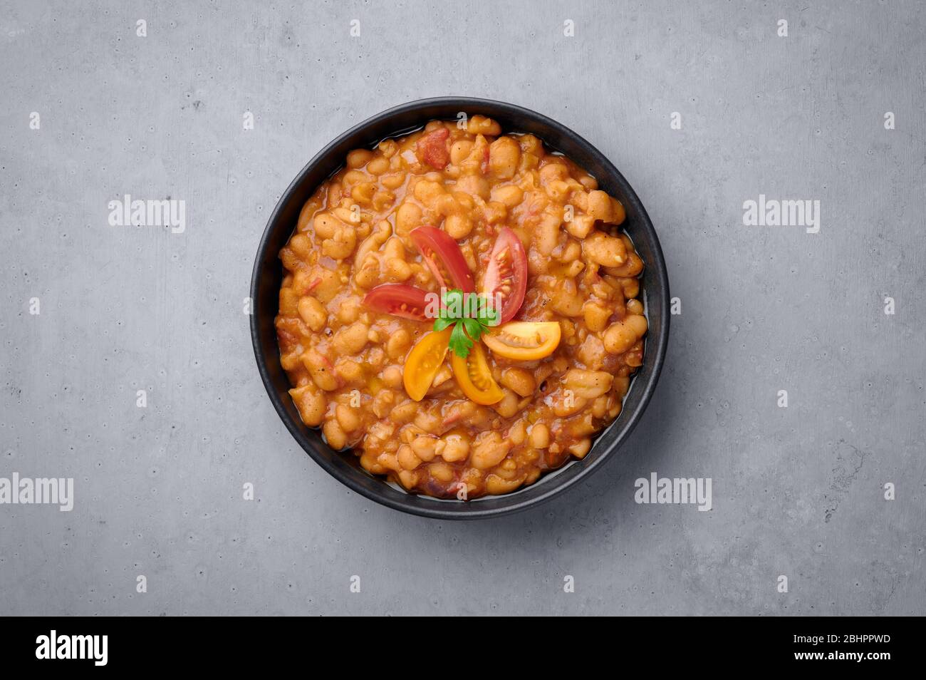 Ful Medames or Fava Beans in black bowl at grey backdrop. Foul Mudammas ...