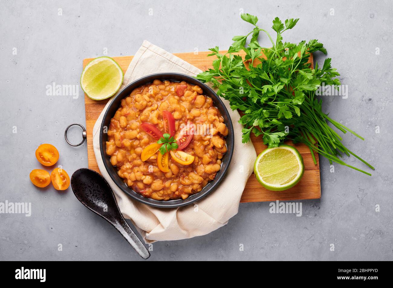 Ful Medames or Fava Beans in black bowl at grey backdrop. Foul Mudammas ...
