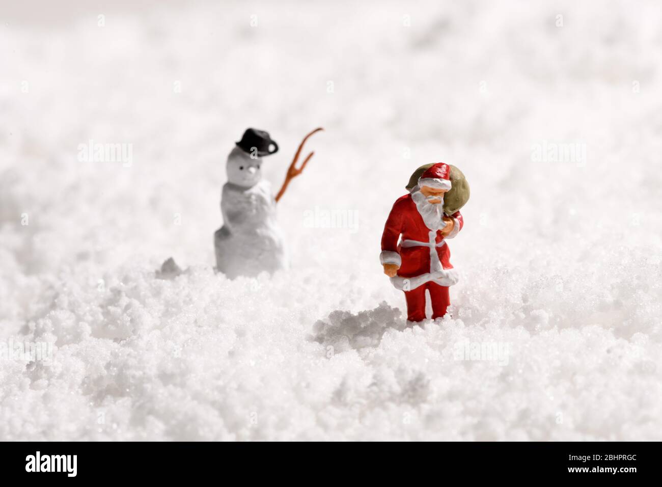 Miniature Father Christmas and a snowman in fresh winter snow in a ...