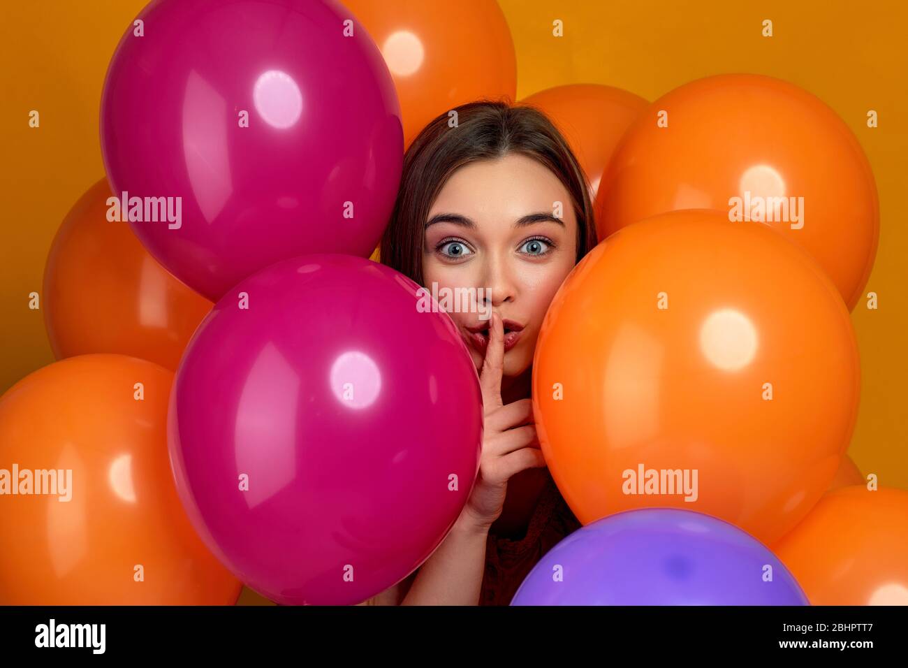 Smiling caucasian girl posing with bright color air balloons showing ...