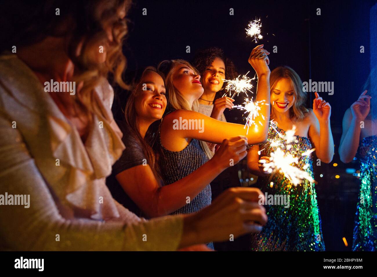 Five women dressed to go out for the evening standing outside with ...