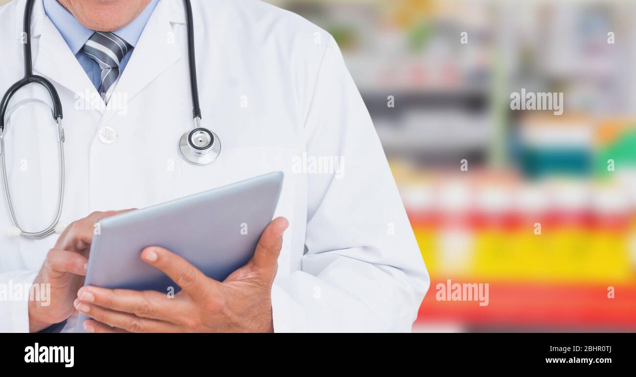 Mid section of male doctor using digital tablet in hospital Stock Photo ...