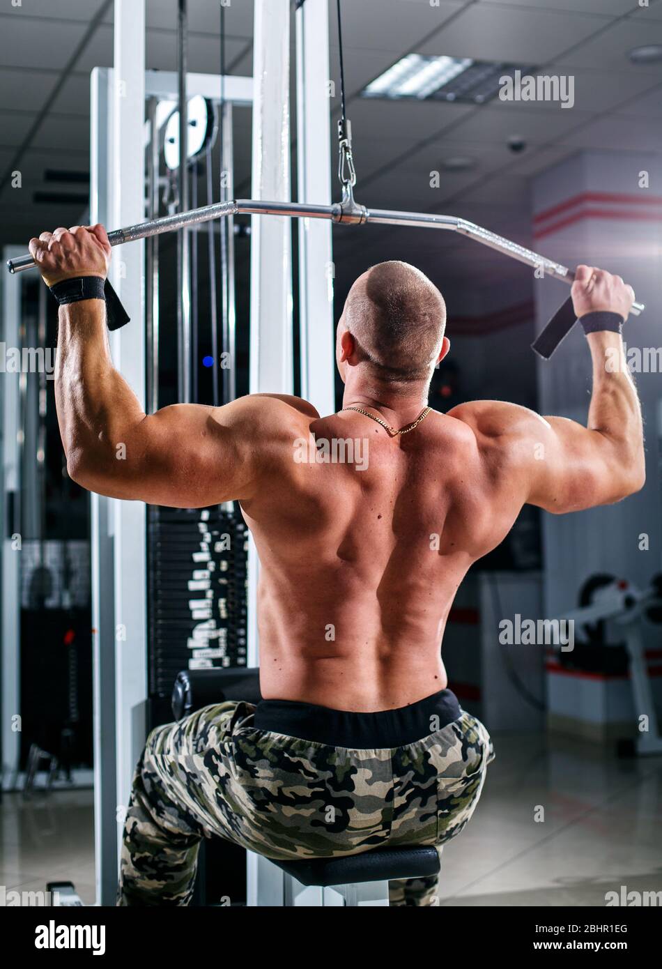 The athlete is engaged in simulators. The man is training his back ...