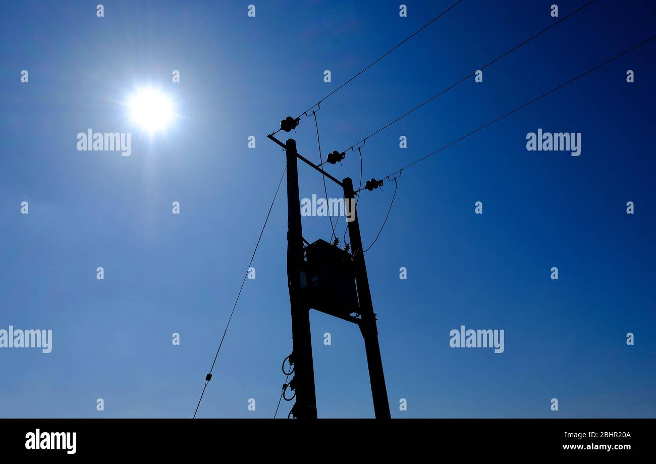 pole mounted overhead electricity transformer on blue sky background ...