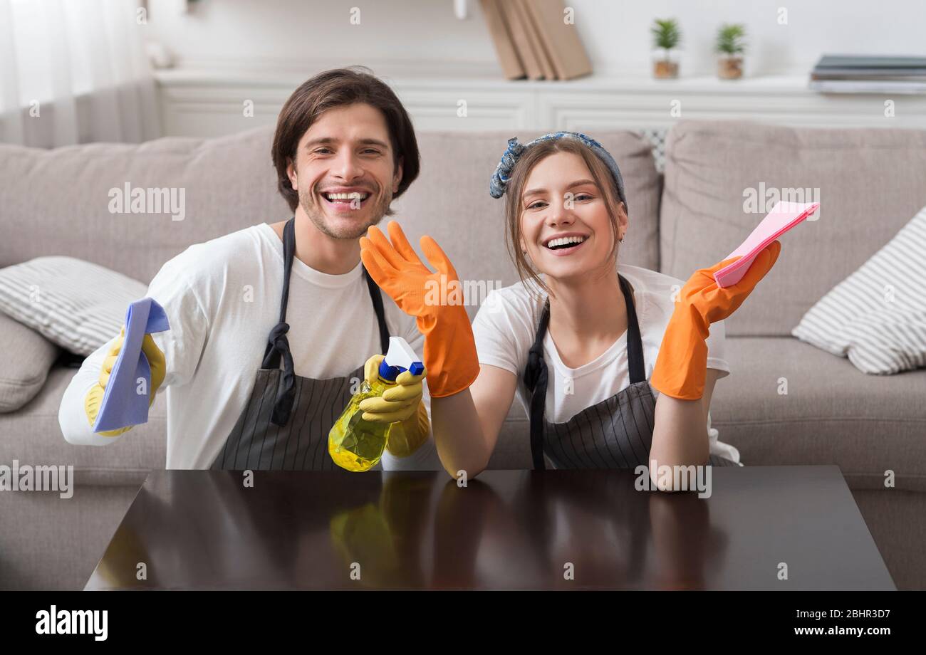 Joyful young couple posing while cleaning up house together Stock Photo ...