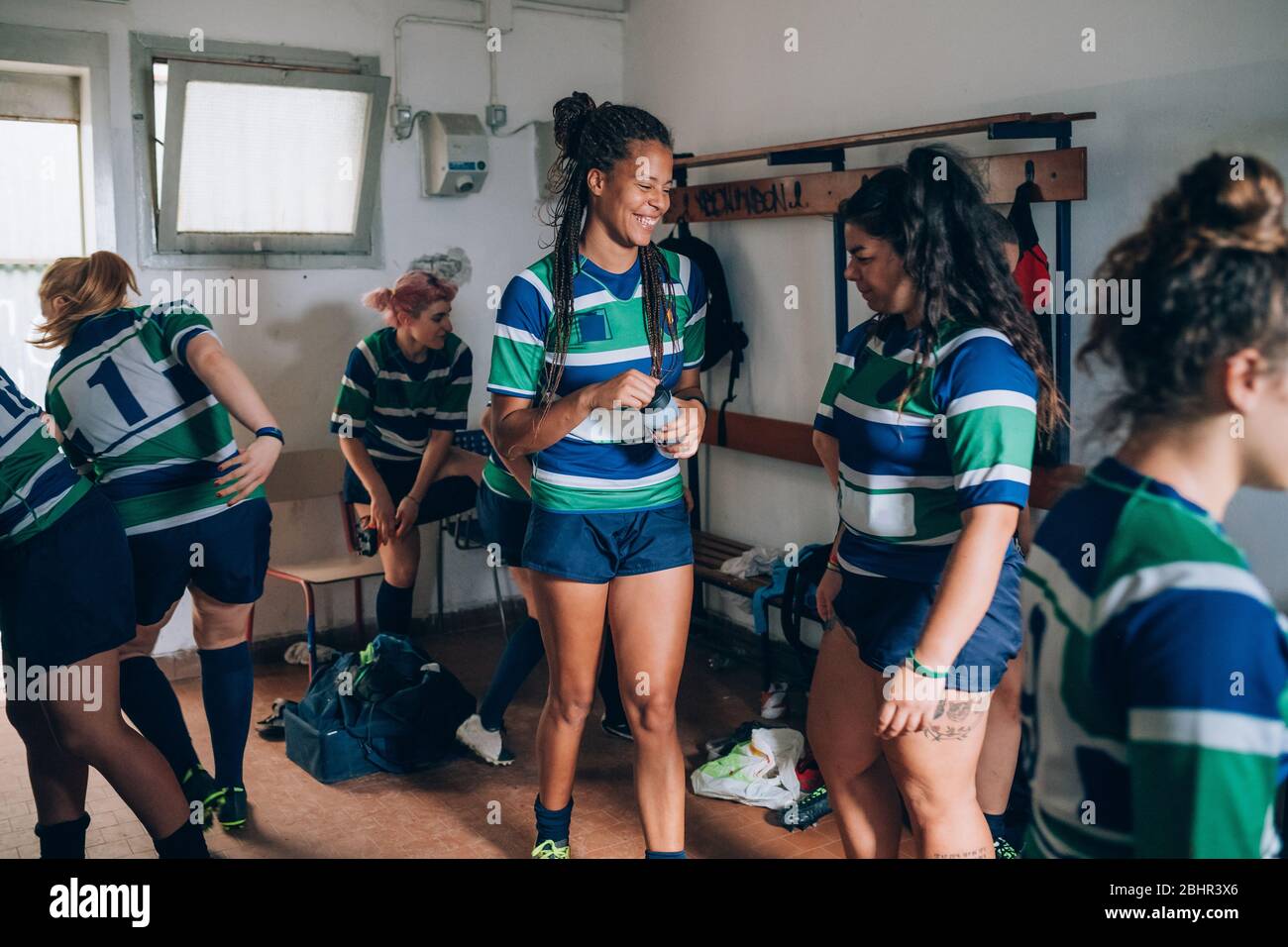 A group of women wearing green, blue and white rugby shirts in a ...