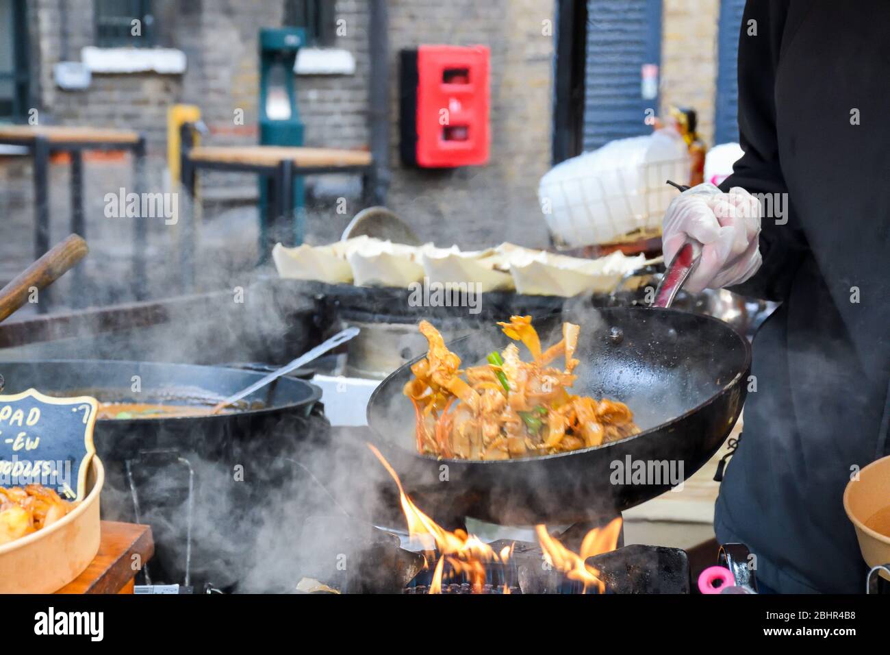 Professional chef and fire. Cooking vegetables and food over an open ...
