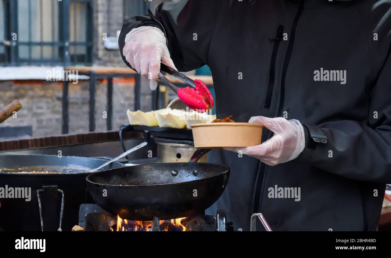 Professional chef and fire. Cooking vegetables and food over an open ...