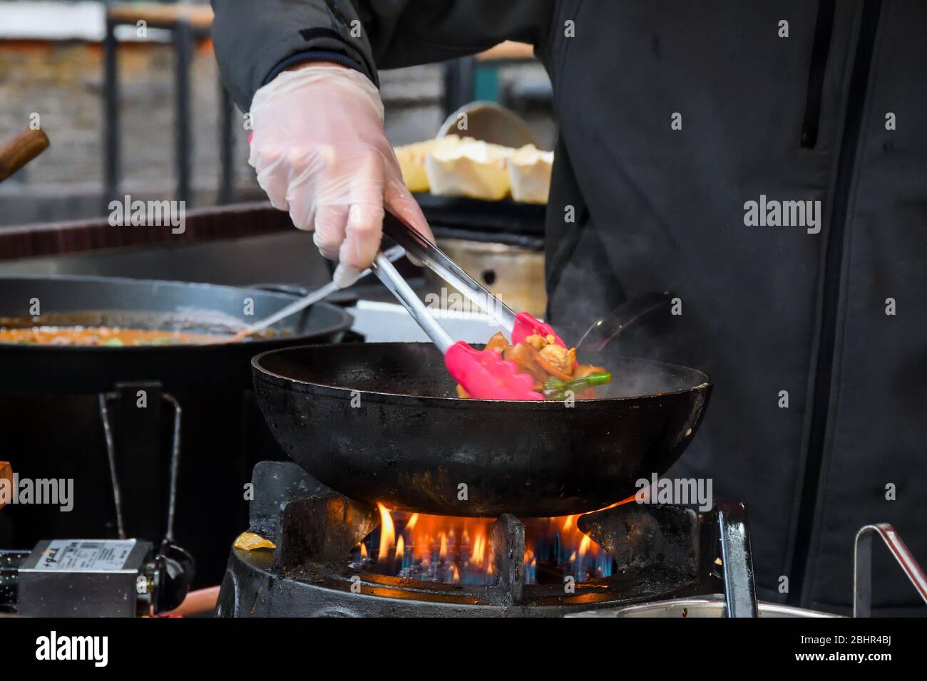 Professional chef and fire. Cooking vegetables and food over an open ...