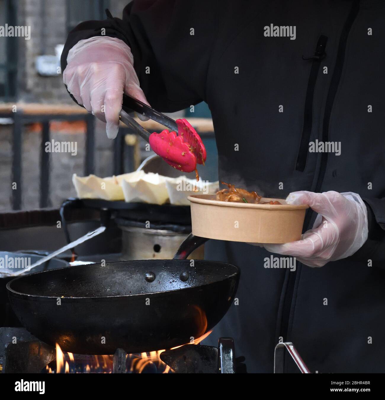 Professional chef and fire. Cooking vegetables and food over an open ...