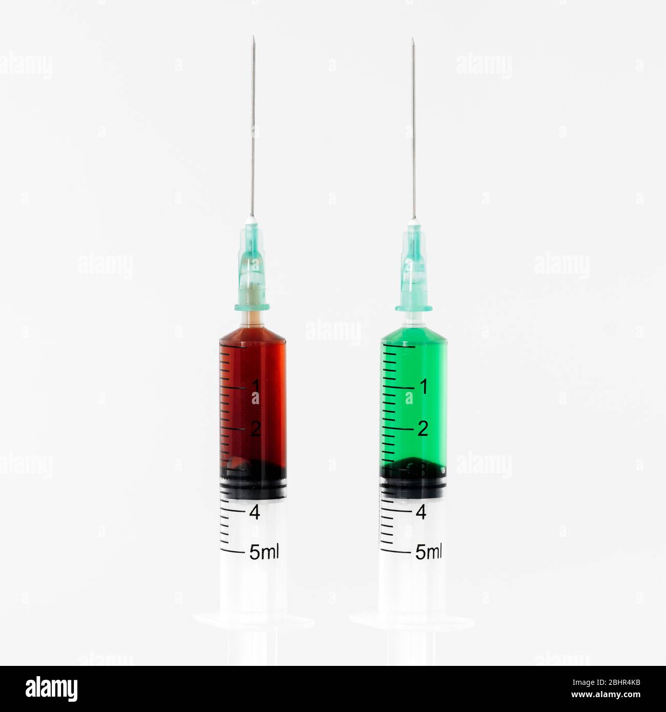 Two syringes with red and green serum isolated on white Stock Photo - Alamy