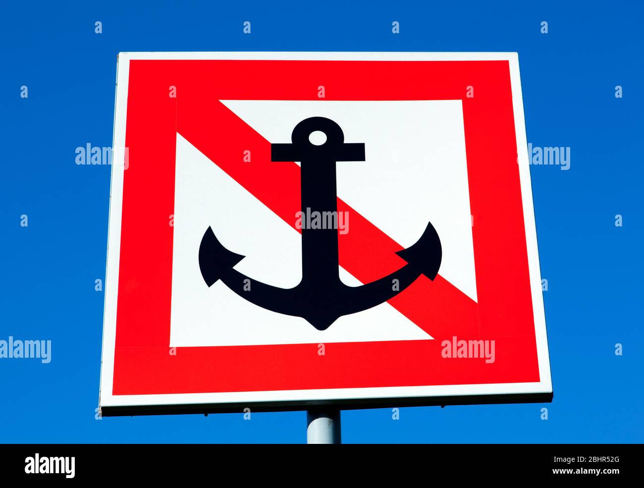 The warning sign with painted anchor prohibiting to dock on a shore of ...