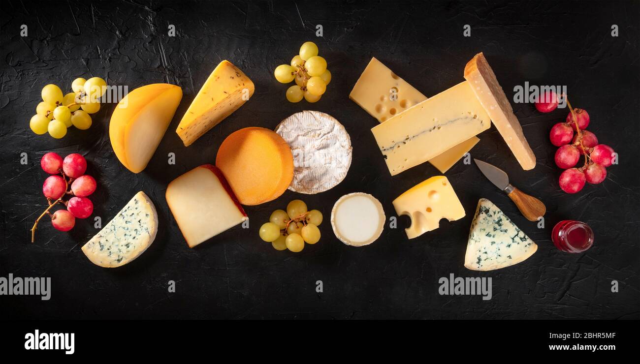 Cheese panorama, various cheeses, shot from above on a dark background ...