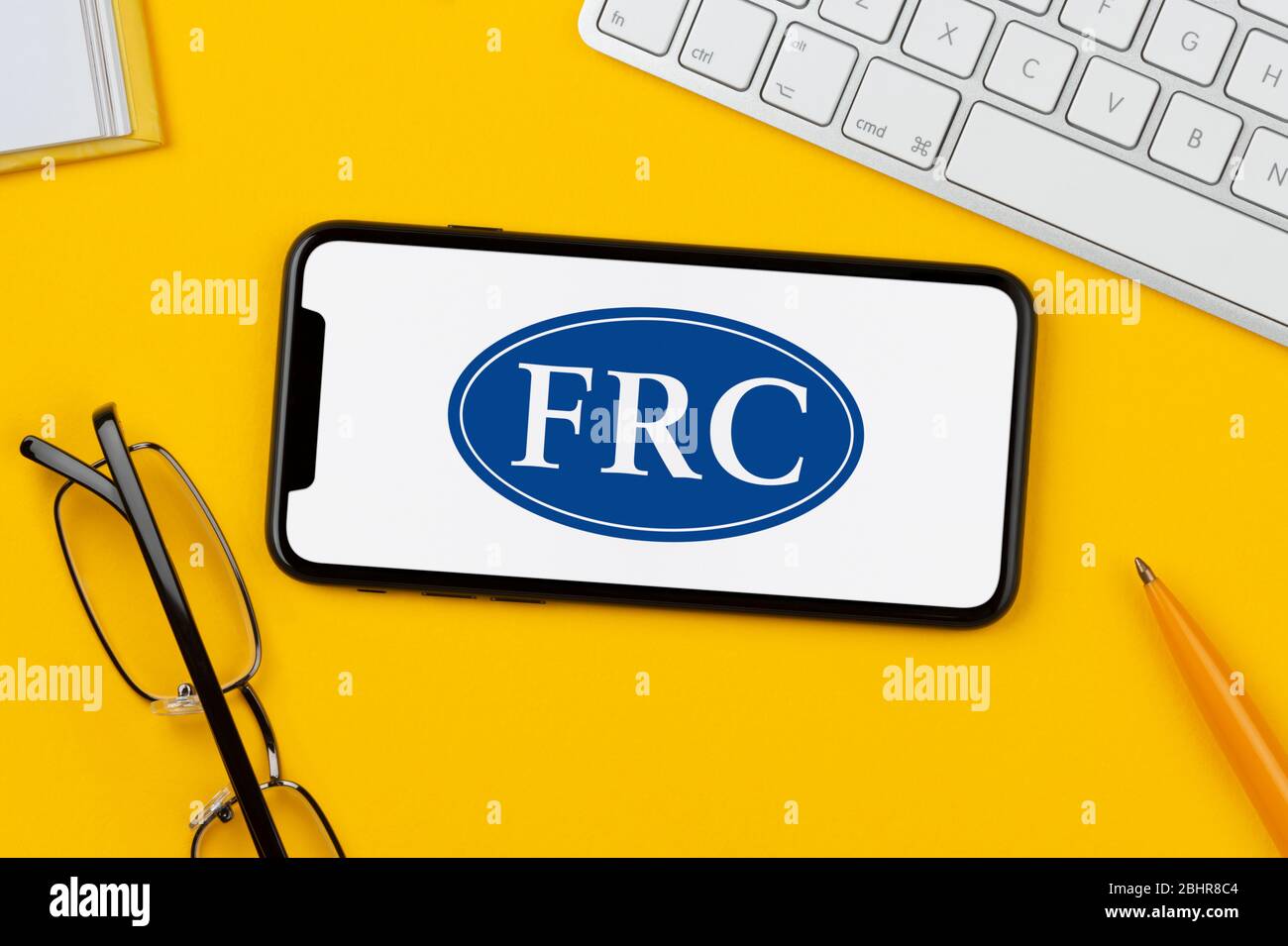 A smartphone showing the FRC logo rests on a yellow background along ...