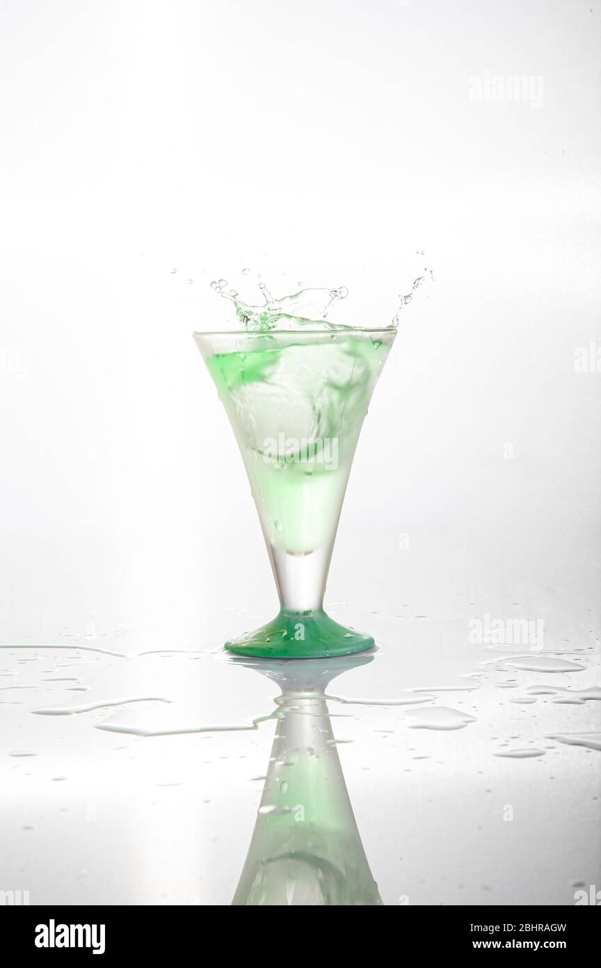 Green alcohol cocktail with splash isolated on white Stock Photo - Alamy