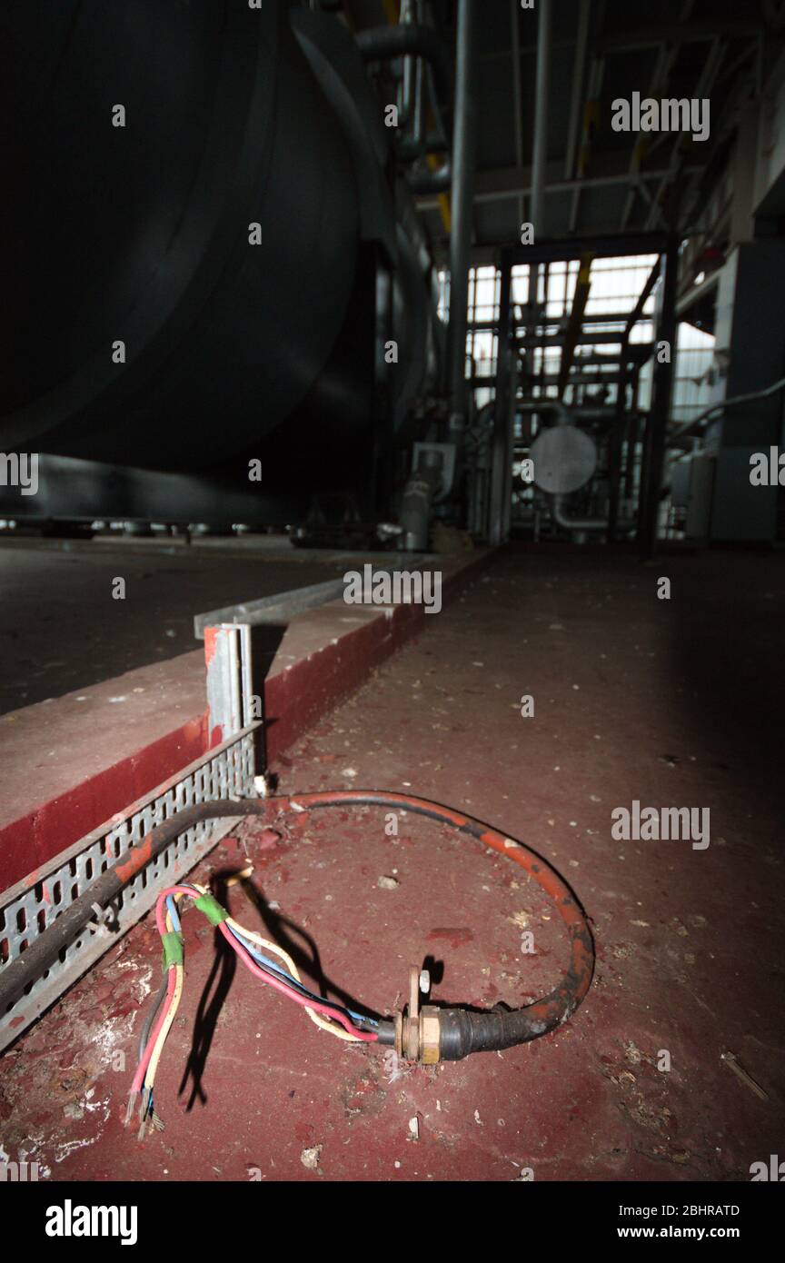 A disconnected bare cable lays loose on the floor of a disused power ...