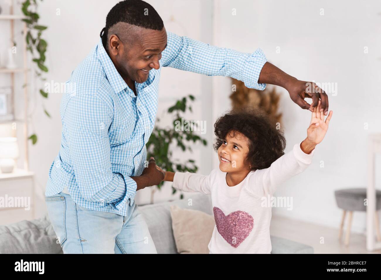 Fun times with grandpa. Older African American man dancing with pretty ...