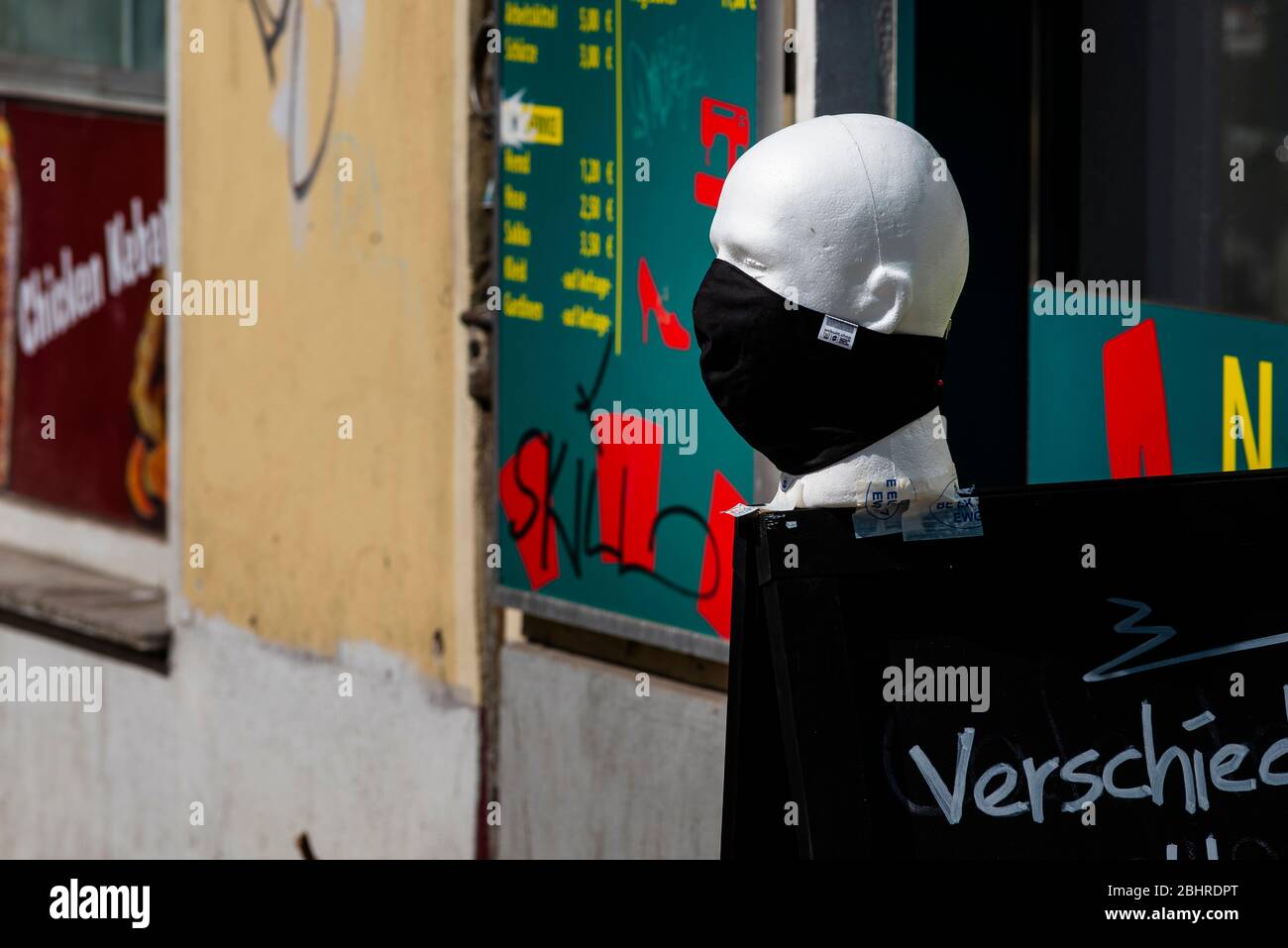 A tailor offers face masks, the head of a mannequin with a face mask ...