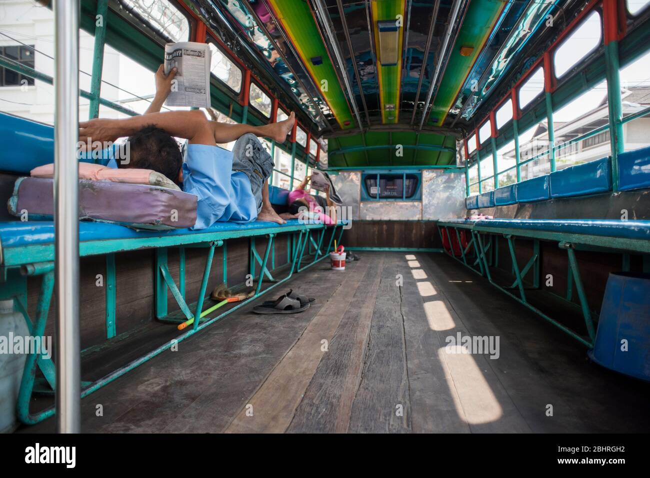 A local Thai bus driver relaxing at the back of his bus, Samut Sakhon ...