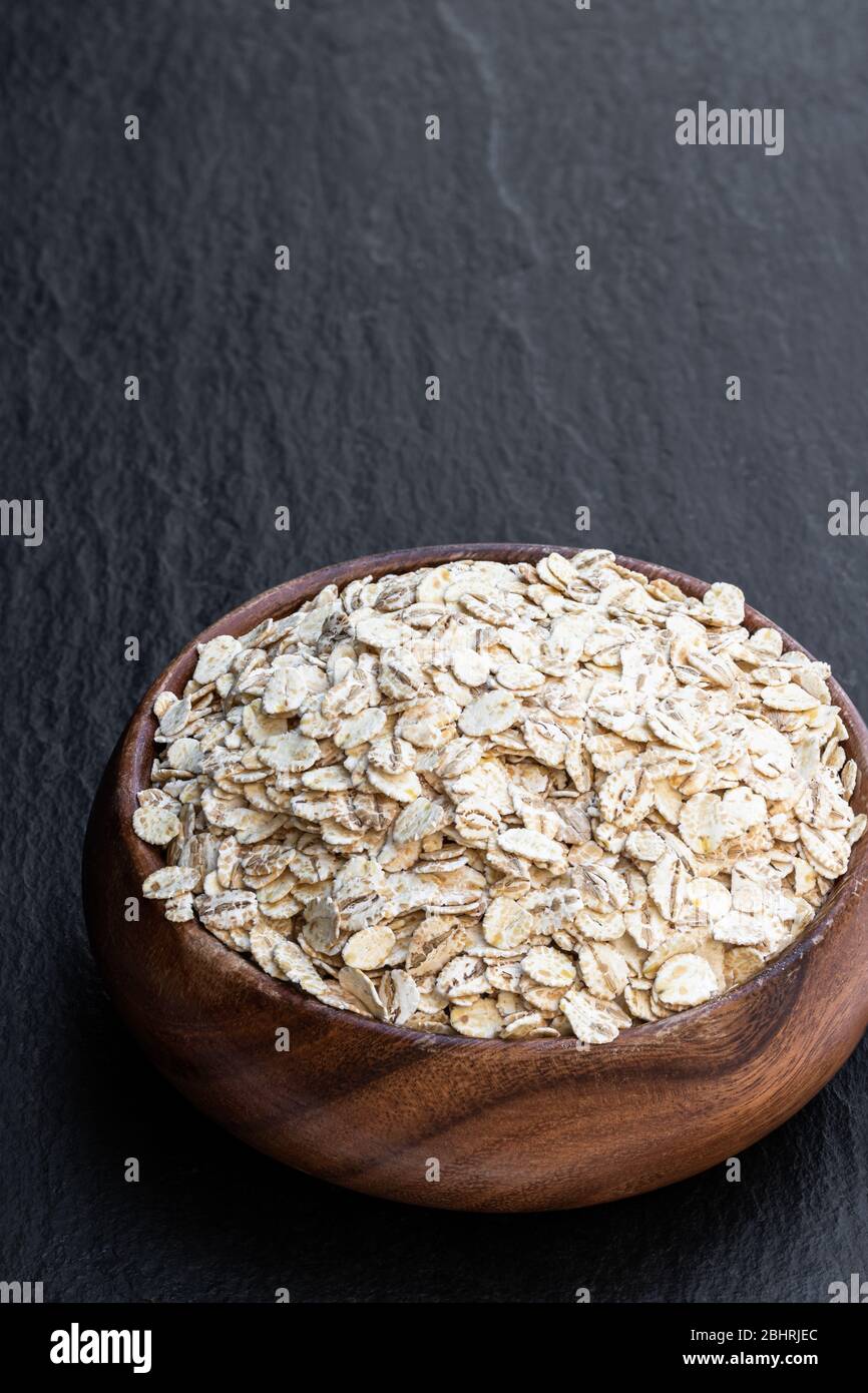 Organic barley flakes in wooden bowl isolated on white Stock Photo - Alamy