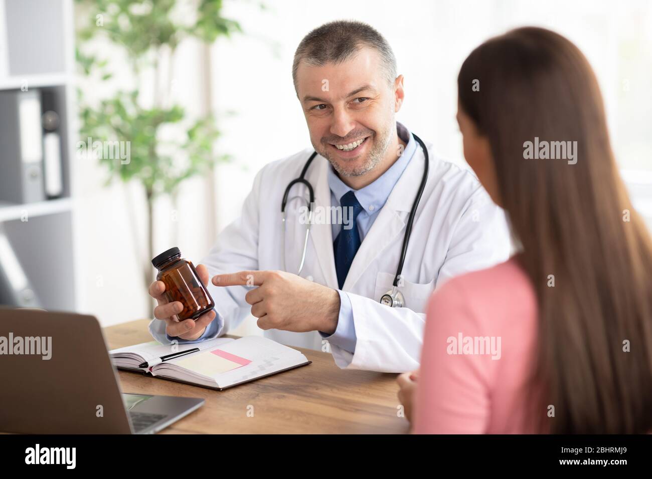 Mature experienced doctor showing pills to female patient Stock Photo ...