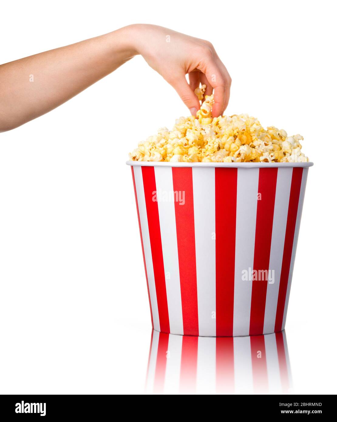 Woman hand picking popcorn from striped bucket isolated on white ...