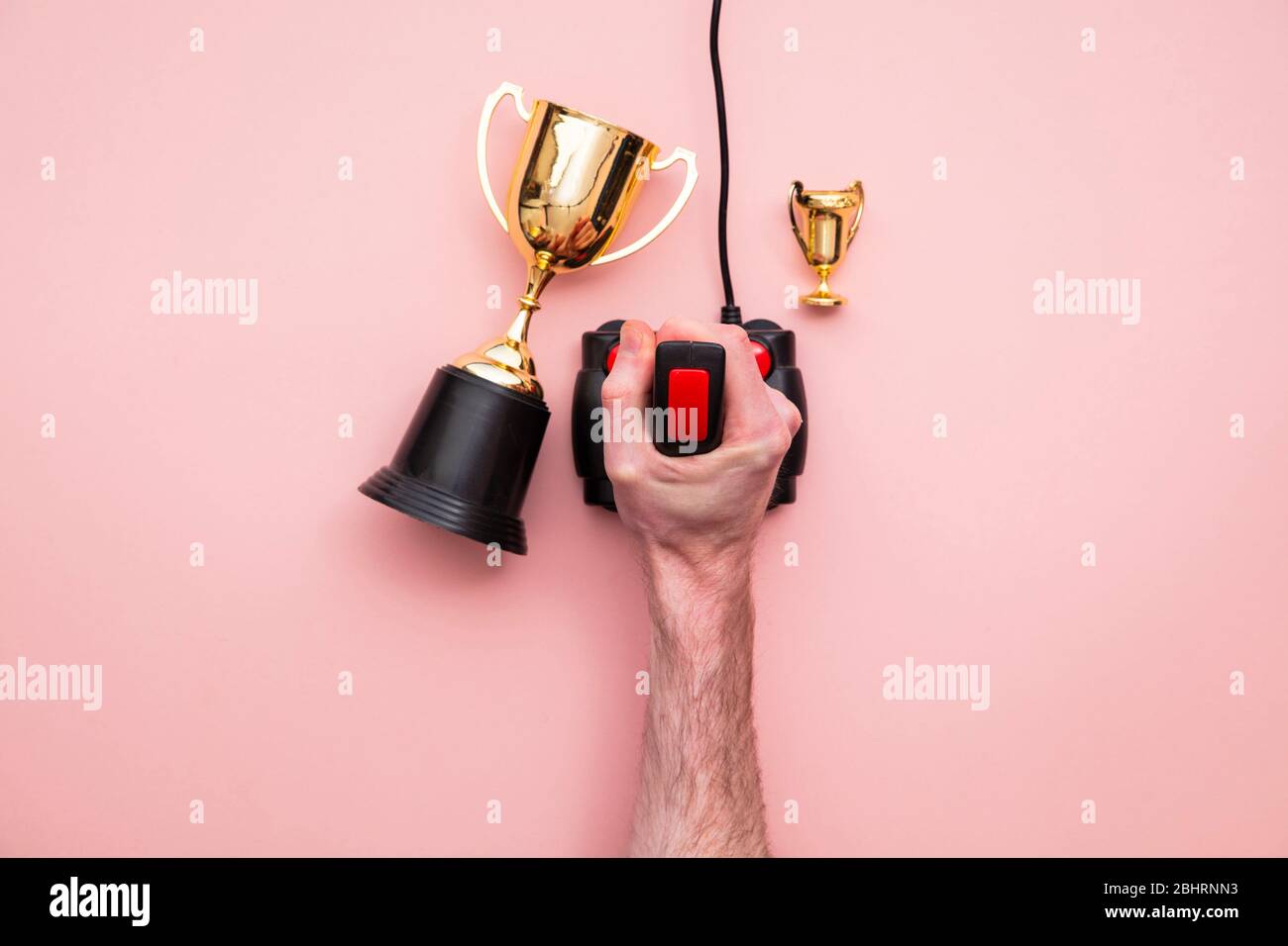winning gamer. Hand using a retro games joystick with a gold winning ...